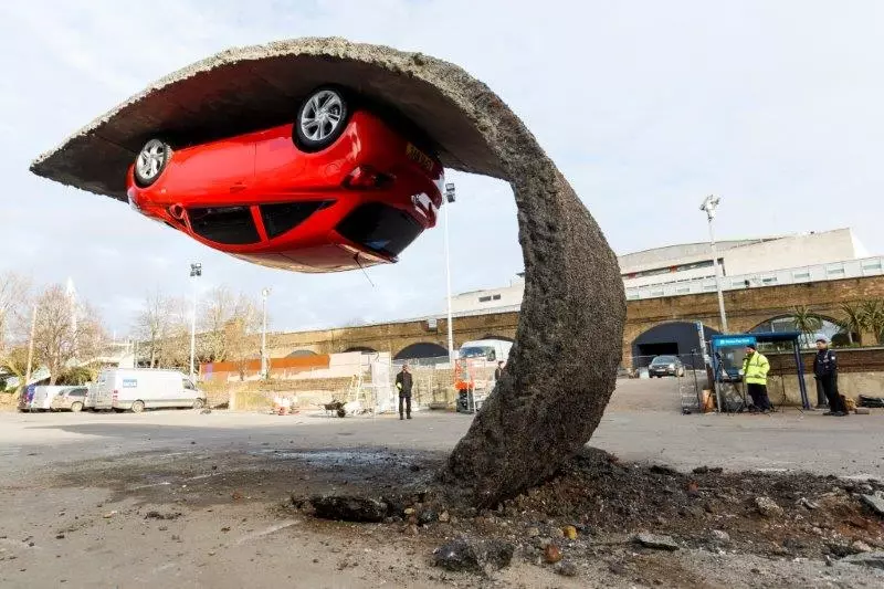 ’n Geparkeerde motor hang 15 voet in die lug terwyl hy nog aan die pad in Londen vas is