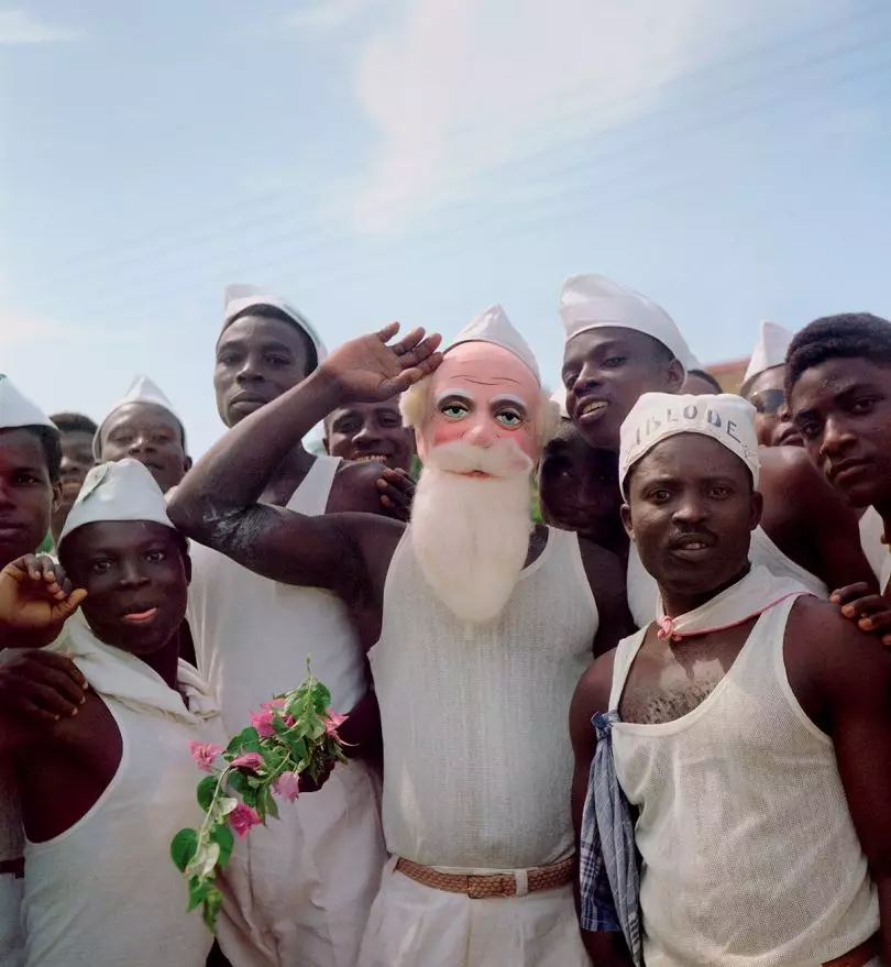 Togoland (Togo), 1958 – Grupo de homens com chapéus brancos, um com o slogan “Ablode” (liberdade), e outro com uma máscara de Papai Noel no dia da eleição, 27 de abril © 2021 Todd Webb Archive