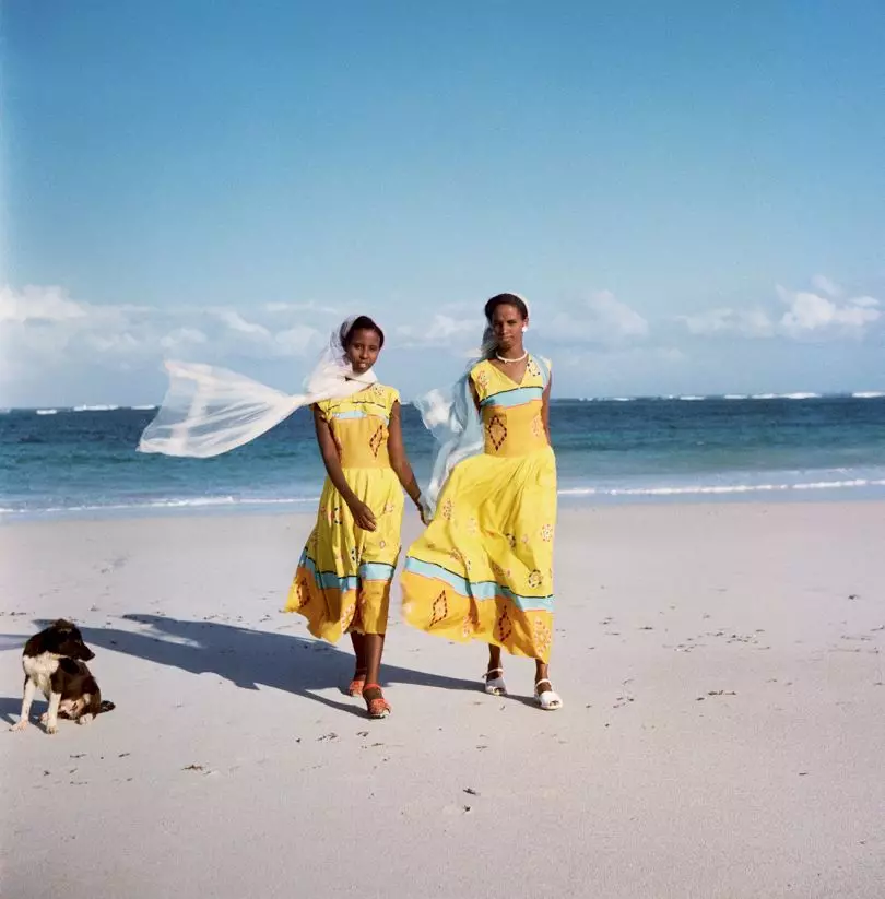 Ebe ntụkwasị obi nke Somaliland (Somalia), 1958 – Ụmụ nwanyị abụọ na-eje ije n'akụkụ osimiri, ha na nkịta n'aka nri ha © 2021 Todd Webb Archive