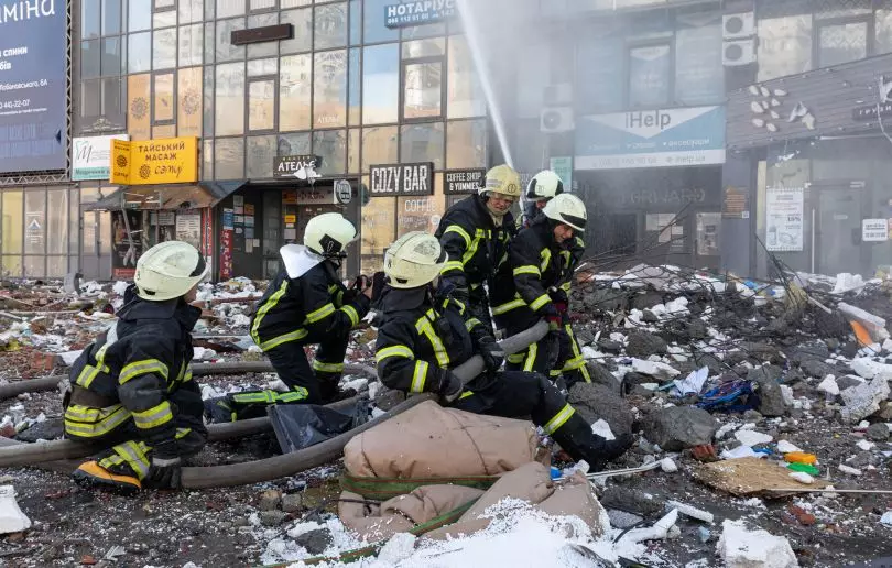 KYIV, UKRAINE - Feb. 25, 2022: Dagaalka Ruushka ee ka dhanka ah Ukraine. Adeegga samatabbixinta wuxuu ka shaqeeyaa meel u dhow guri uu burburiyay gantaalka Ruushka ee Kyiv - Sawirka palinchak