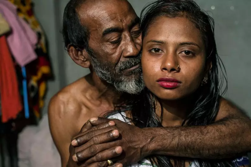 Kajol med en kunde. Hun tror hun er 17 år, men vet ikke hennes eksakte alder. Hun var gift i 9 år. Tanten hennes solgte henne til bordellet i Kandapara. Hun har en 6 måneder gammel sønn, Mehedi. To uker etter fødselen ble hun tvunget til å ha sex igjen med kunder. På grunn av babyen har ikke virksomheten hennes vært så bra. © Sandra Hoyn. Vinner av Photojournalism Series, Magnum og LensCulture Photography Awards 2016.