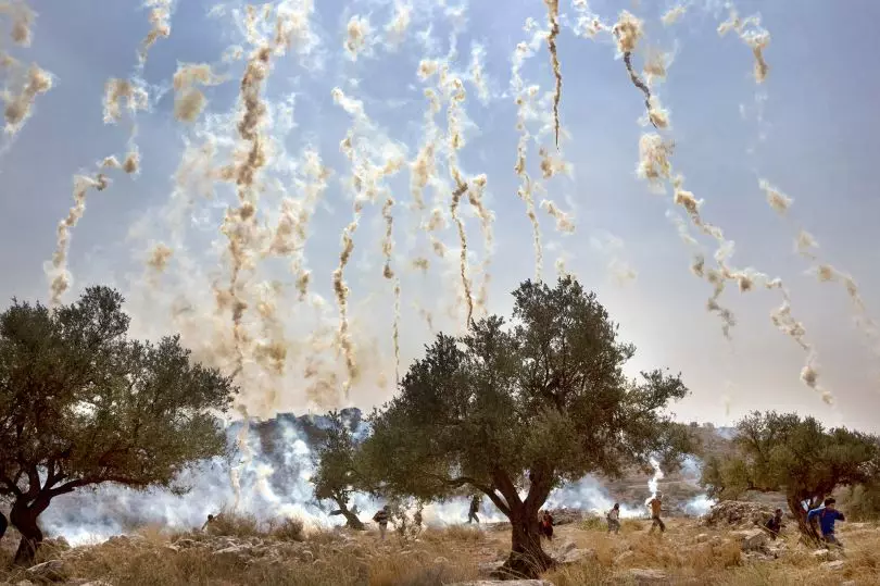 Israelske soldater skyter tåregass under en demonstrasjon mot Israels kontroversielle separasjonsbarriere i landsbyen Nilin på Vestbredden. © Cris Toala Olivares / De Beeldunie. Dokumentarvinner av enkeltbilde, Magnum og LensCulture Photography Awards 2016