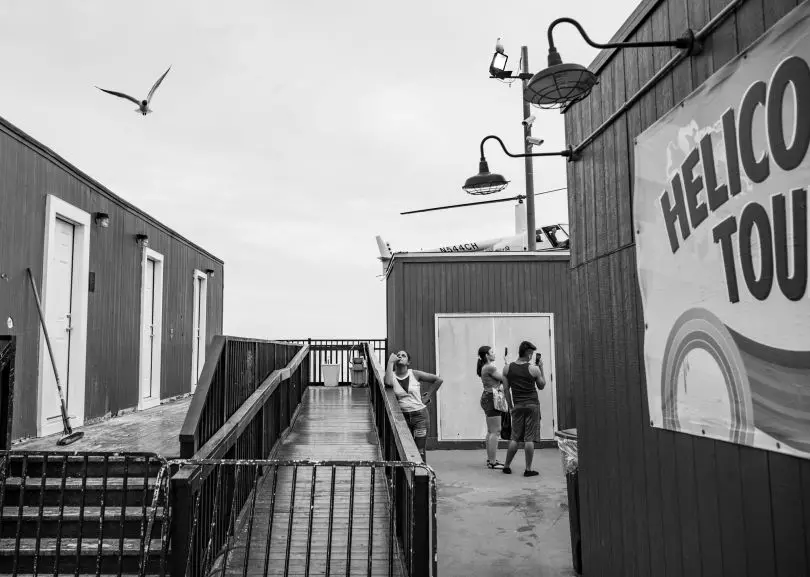 Kunden warten auf eine Rundfahrt mit dem Steel Pier-Hubschrauber an der Küste. © Timothy Roberts