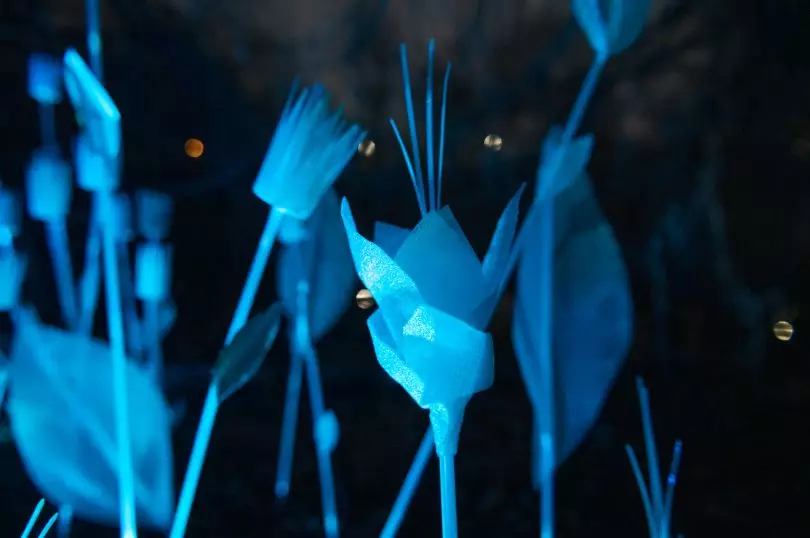 Pflanzen und Blumen, die vollständig aus nicht recycelbarem Müll bestehen, beleuchtet in einem dunklen Wald in Berlin 8590_12