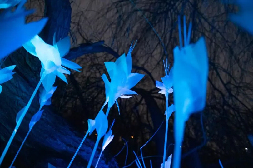 Pflanzen und Blumen, die vollständig aus nicht recycelbarem Müll bestehen, beleuchtet in einem dunklen Wald in Berlin 8590_5