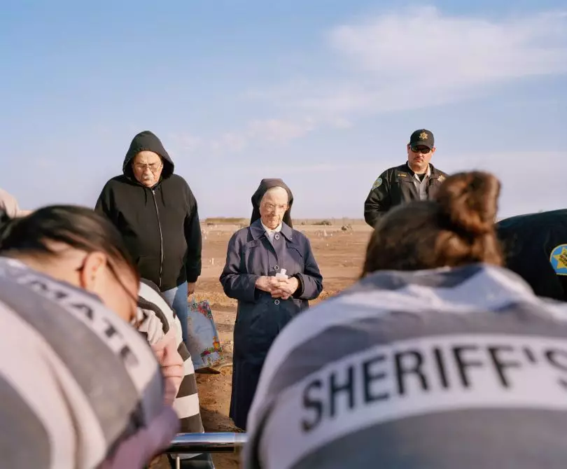 Sister Mary Ruth Dittman watches a coffin being lowered during burial duty