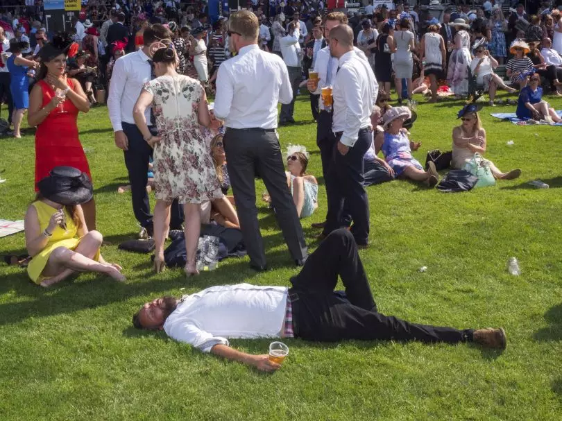 En man med sin pint vilar på gräset på Royal Ascot. Juni 2017. All fotografering med tillstånd av Peter Dench. © Peter Dench