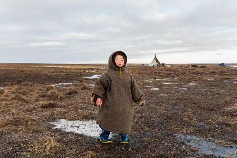 Para Christina, de cuatro años, el vasto paisaje abierto de la tundra en otoño es su patio de recreo, y juega a romper el hielo delgado que se forma sobre los charcos de agua. Poco a poco, a medida que llega el invierno, el aire se vuelve más fresco y las temperaturas comienzan a descender constantemente. Las capas de hielo comienzan a espesarse y Christina disfruta mucho rodando sobre el espeso hielo congelado. Crédito de la imagen: Alegra Ally/Schilt Publishing