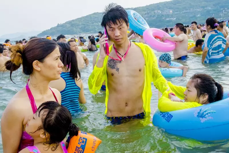 Foto's die China's obsessie met smartphones onthullen terwijl ze zonnebaden op 'Silicon Beach'