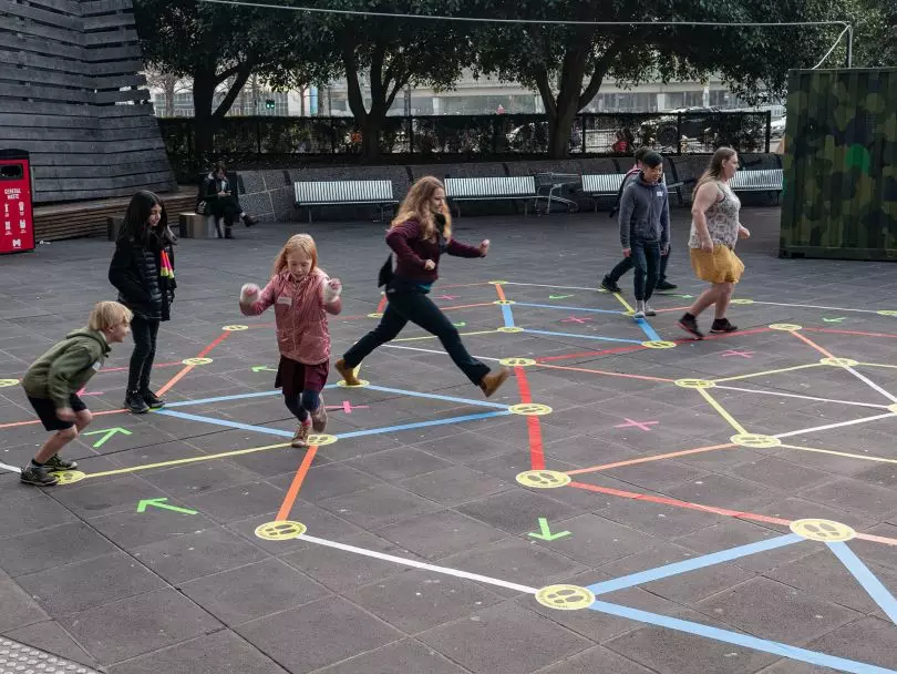 Гудамжны соронзон хальсны тоглоомууд – Нийгмийн алслагдсан дүрмийн дагуу бүтээгдсэн тоглох боломжтой урлагийн инсталляци, нийгэмээс тусгаарлах соронзон хальс, дүрмийн үүрэг ролийг үгүйсгэж, хөгжилтэй хамтын тоглоом бий болгох. Хелен Квок, Чад Топрак нар илгээсэн, 2020-21, Мельбурн, Австрали © Street Tape Games
